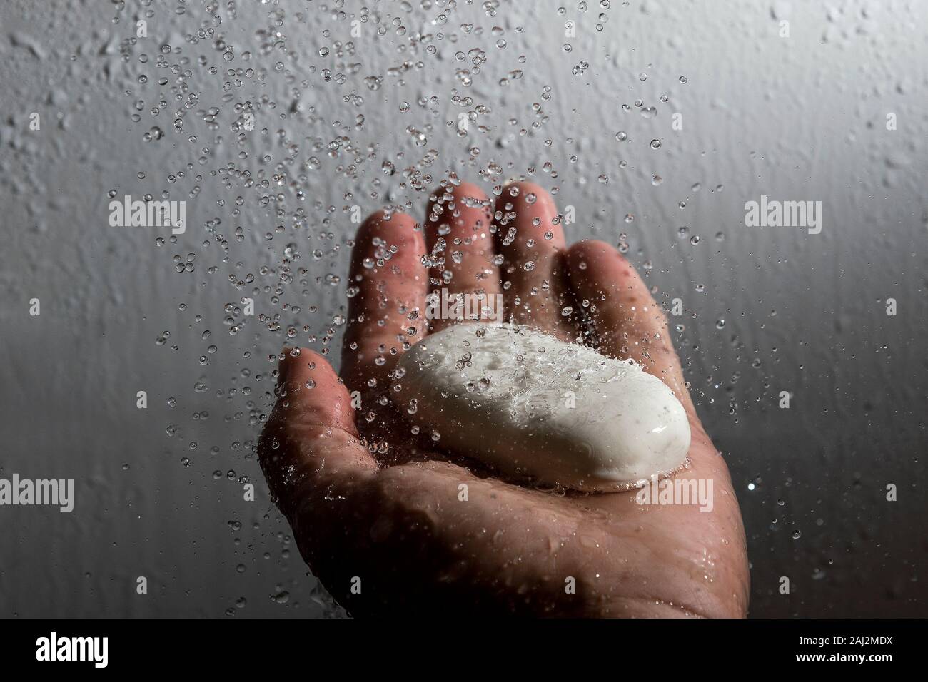 Soap in human hands and falling water Stock Photo - Alamy