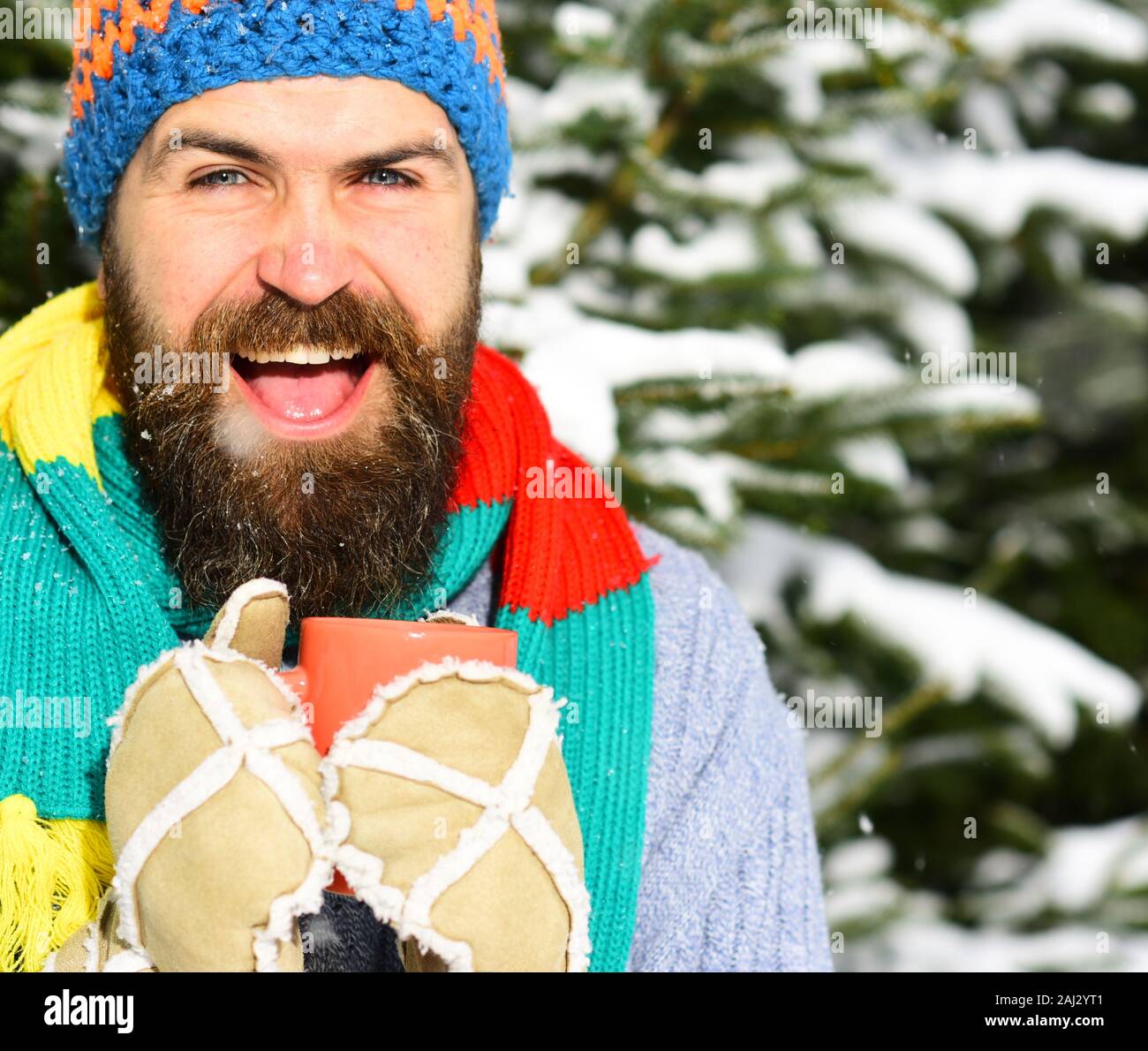 Warming drinks concept. Guy with firtrees covered with snow on ...