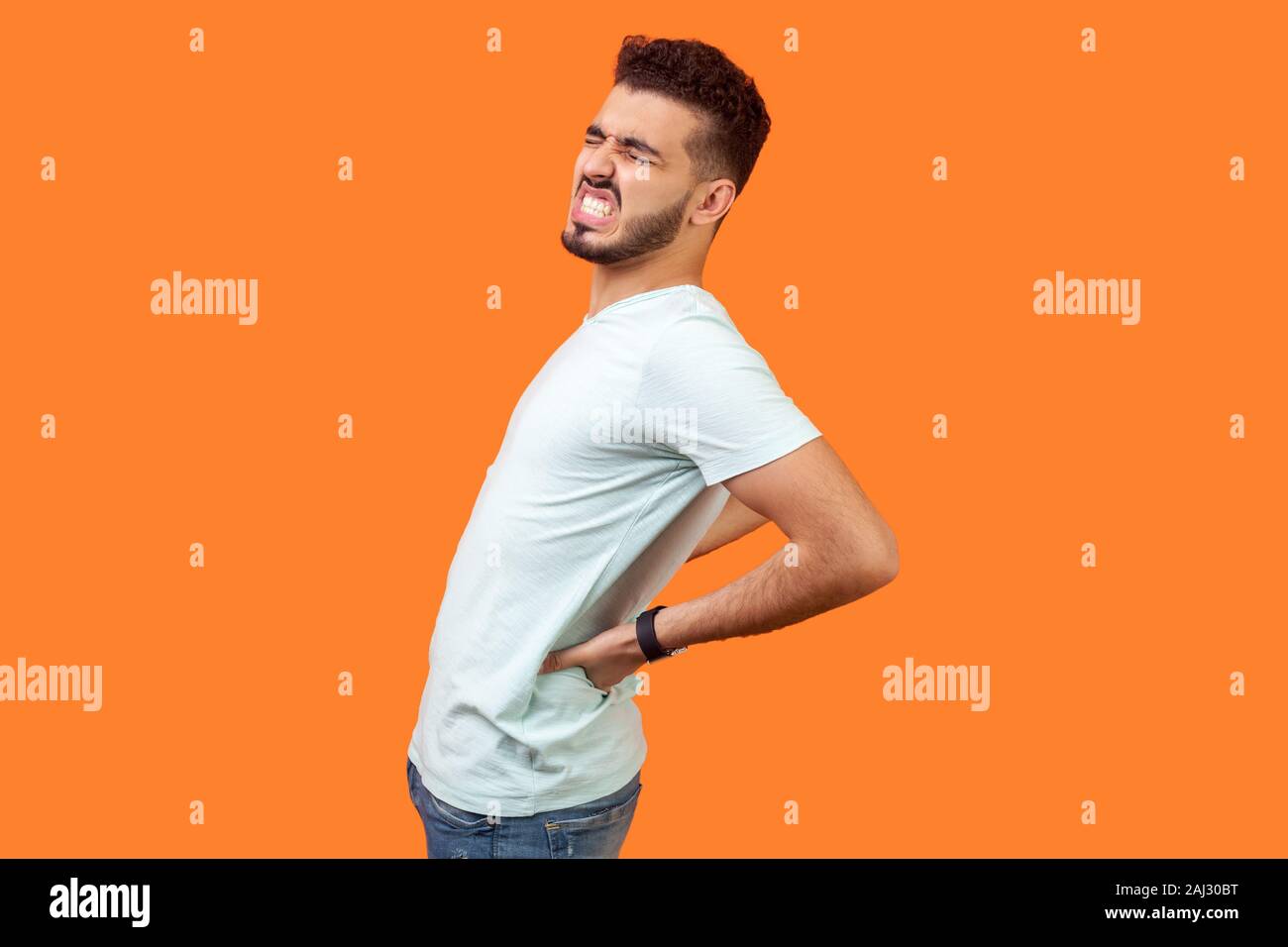 Spine problems. Portrait of brunette man in casual white t-shirt ...