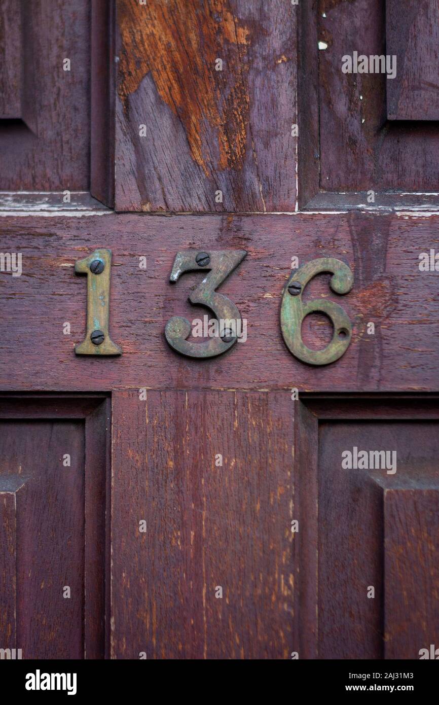 Worn and weathered house number 136 Stock Photo - Alamy