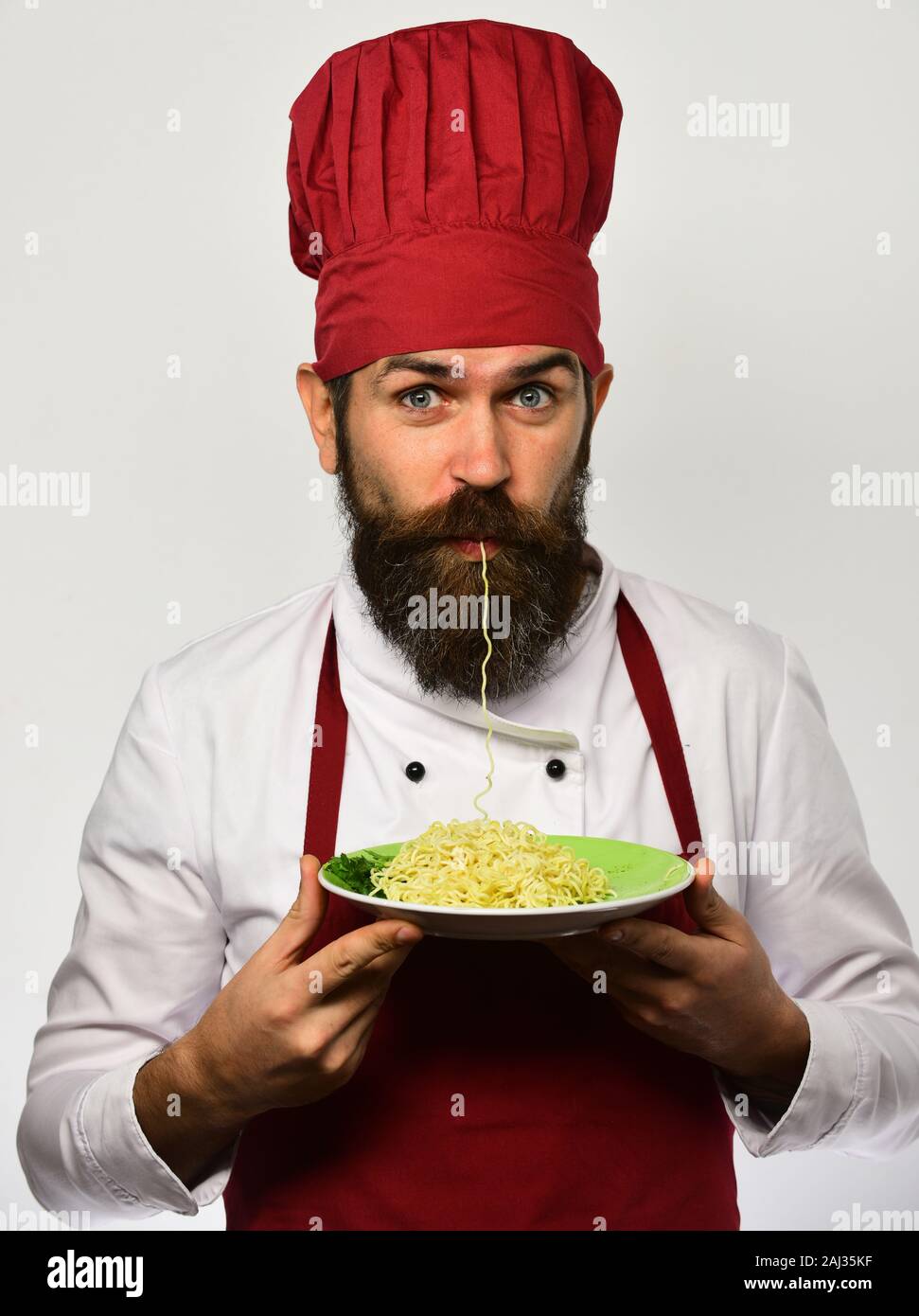 Chef eats italian or asian noodles. Cook with cheerful face in burgundy ...