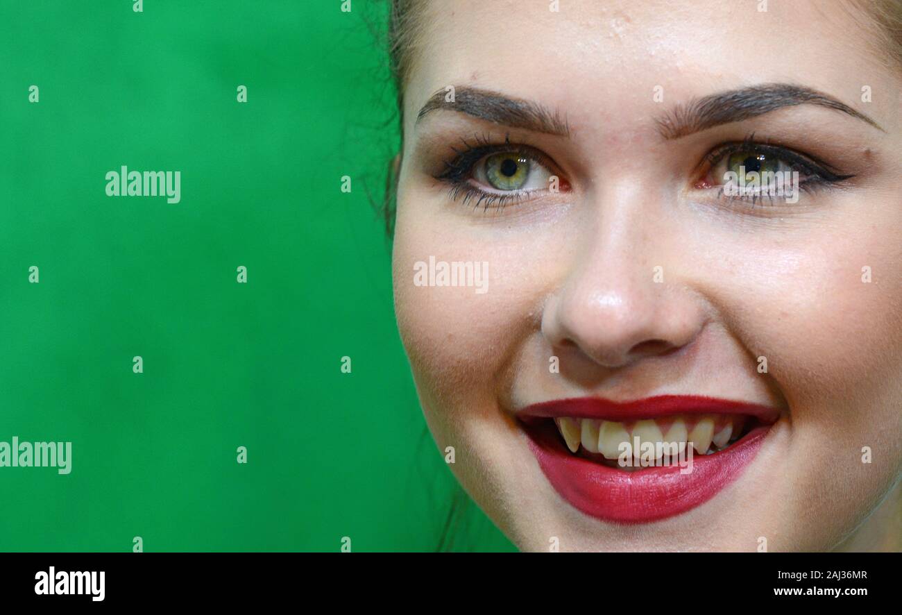 Female model with face against a green screen Stock Photo - Alamy