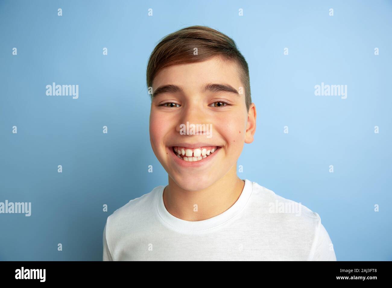Smiling, happy. Close up. Caucasian boy portrait isolated on blue ...
