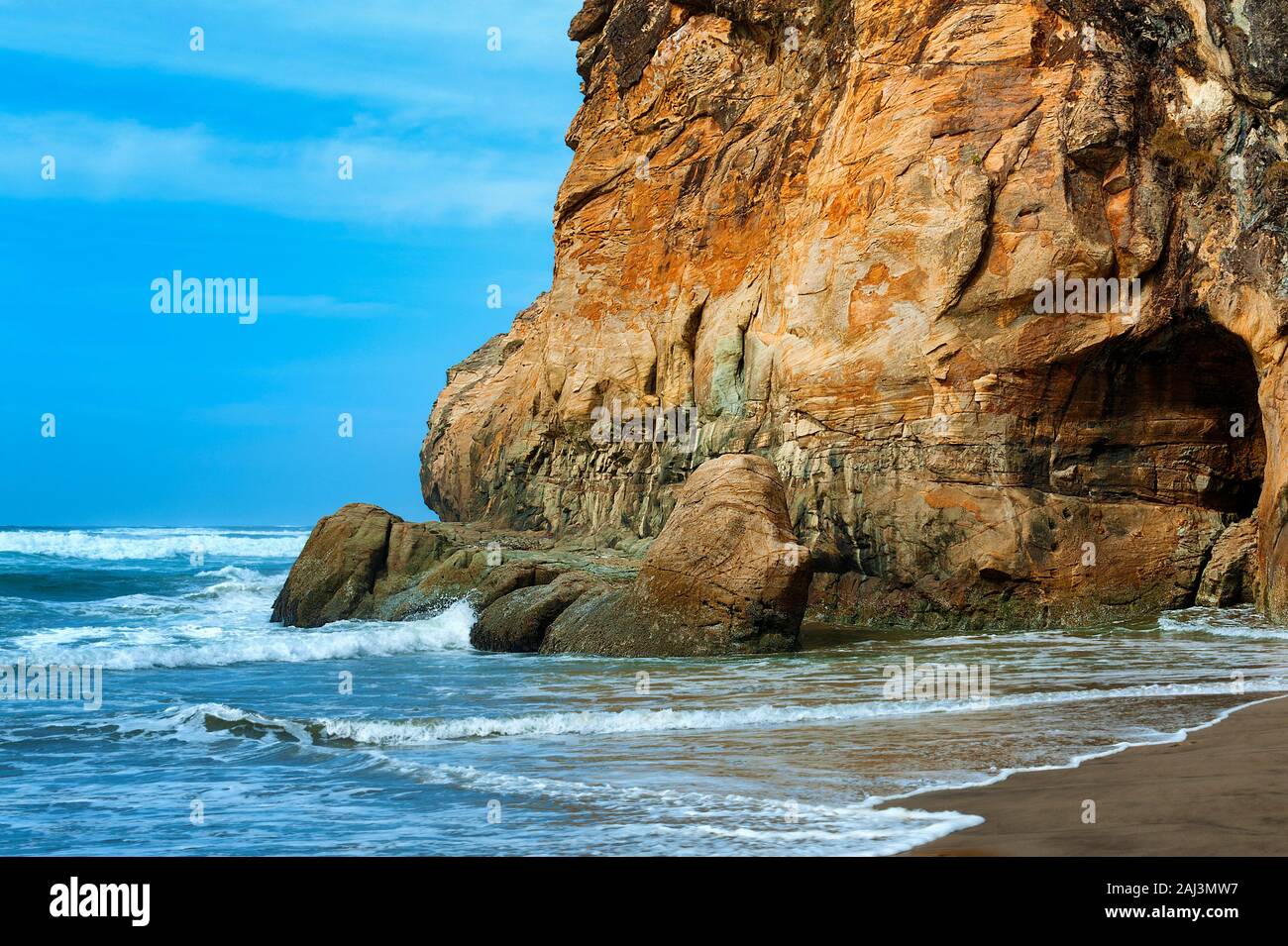 Tide rising at Hug Point on the Oregon Coast around sandstone cliffs ...