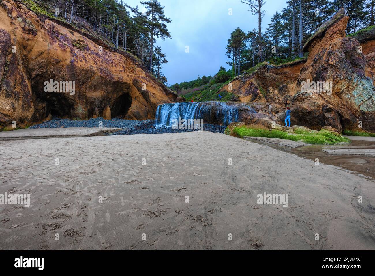 Teenagers explore around the Hug Point Waterfalls at low tide on the ...