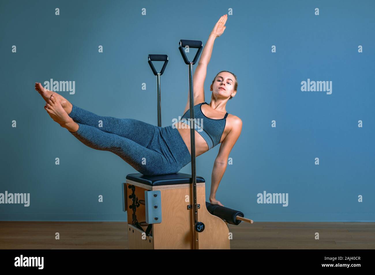 Pilates woman in a reformer doing stretching exercises in the gym ...