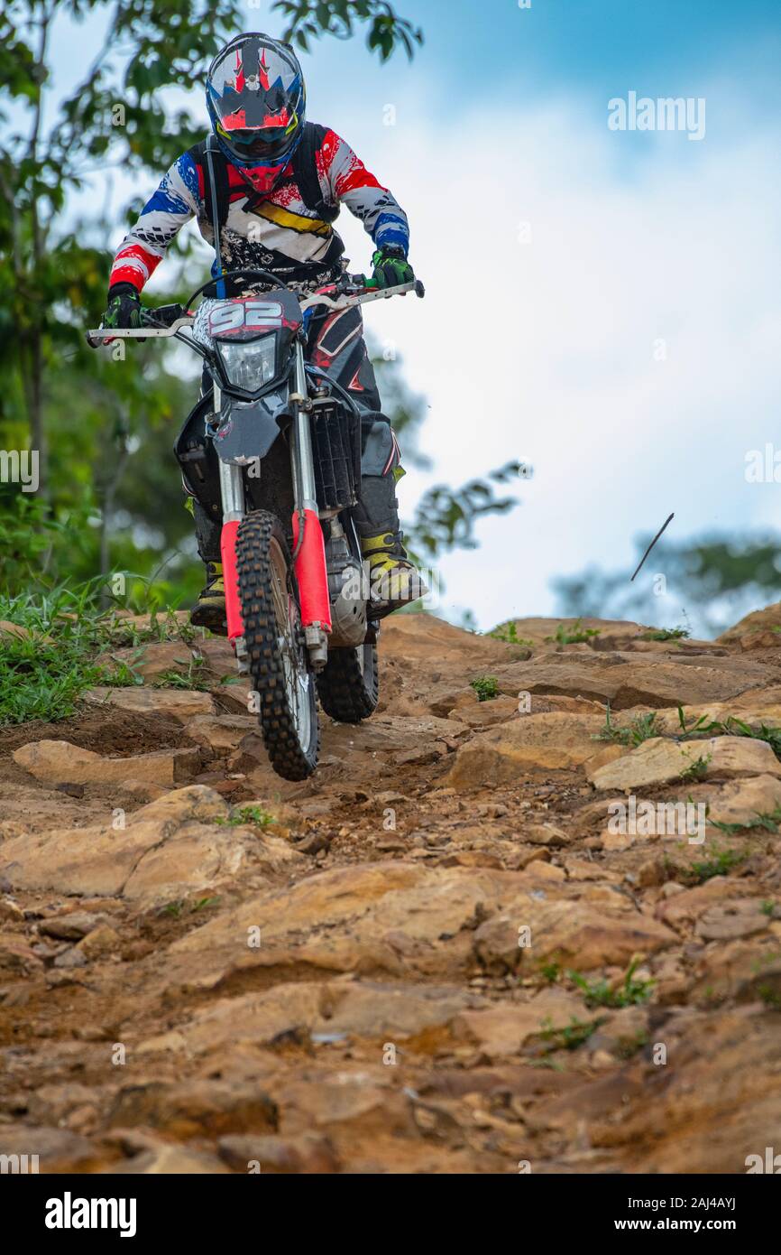 Man on off road bike riding down a hill on a rough trail Stock Photo ...