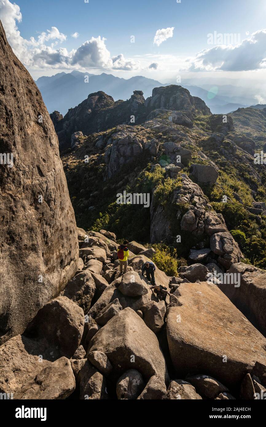 People hiking and climbing rocky section of mountain in Morro do Couto ...