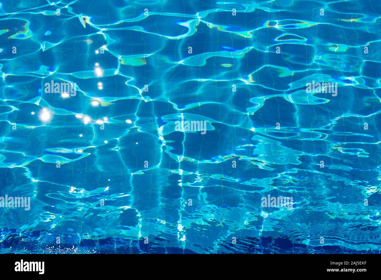 Blue bottom through the transparent water with sunspots of light in the ...