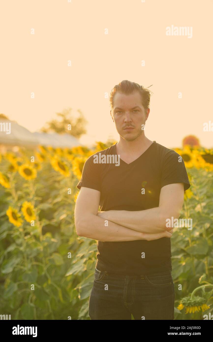 Young man standing sunflower in hi-res stock photography and images - Alamy