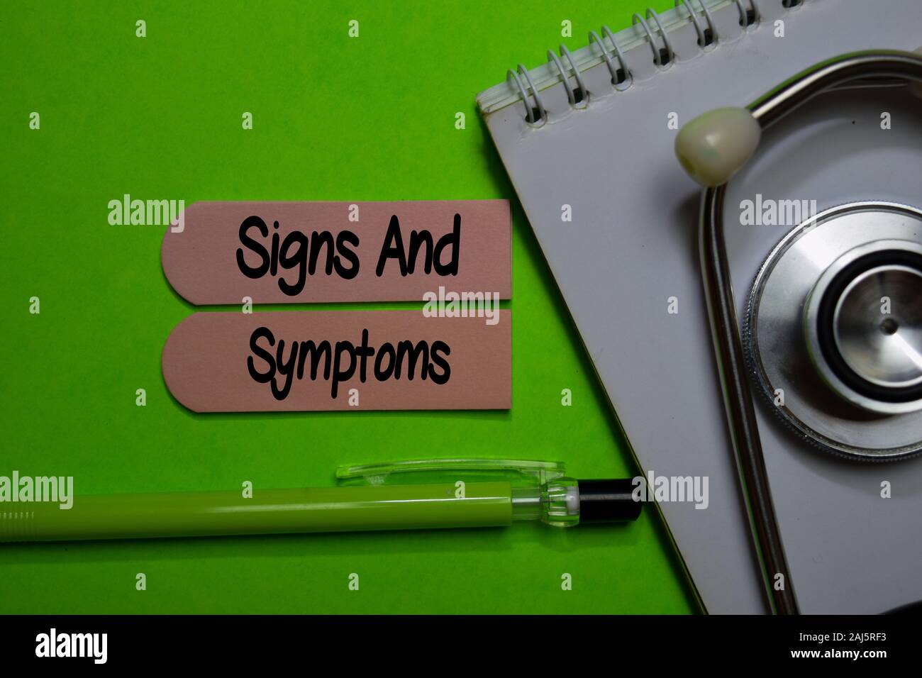Signs And Symptoms write on sticky note isolated on Office Desk ...