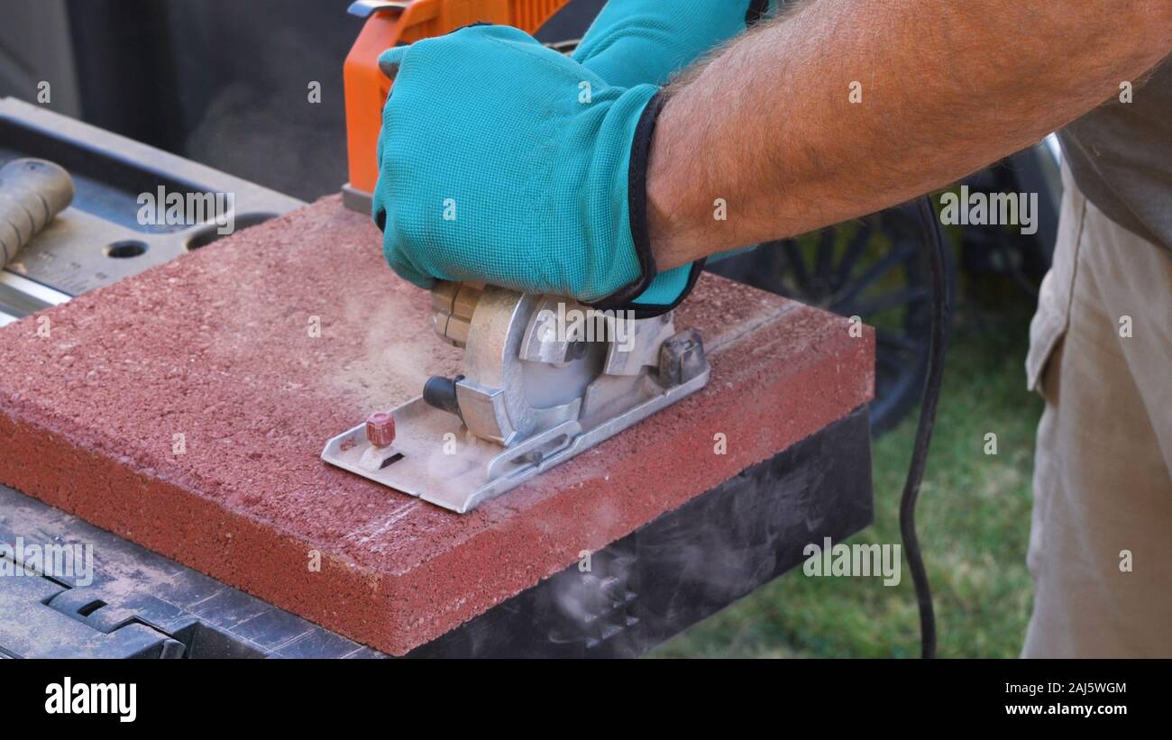 Tile cutter industry equipment. Worker cutting paving tiles for laying ...