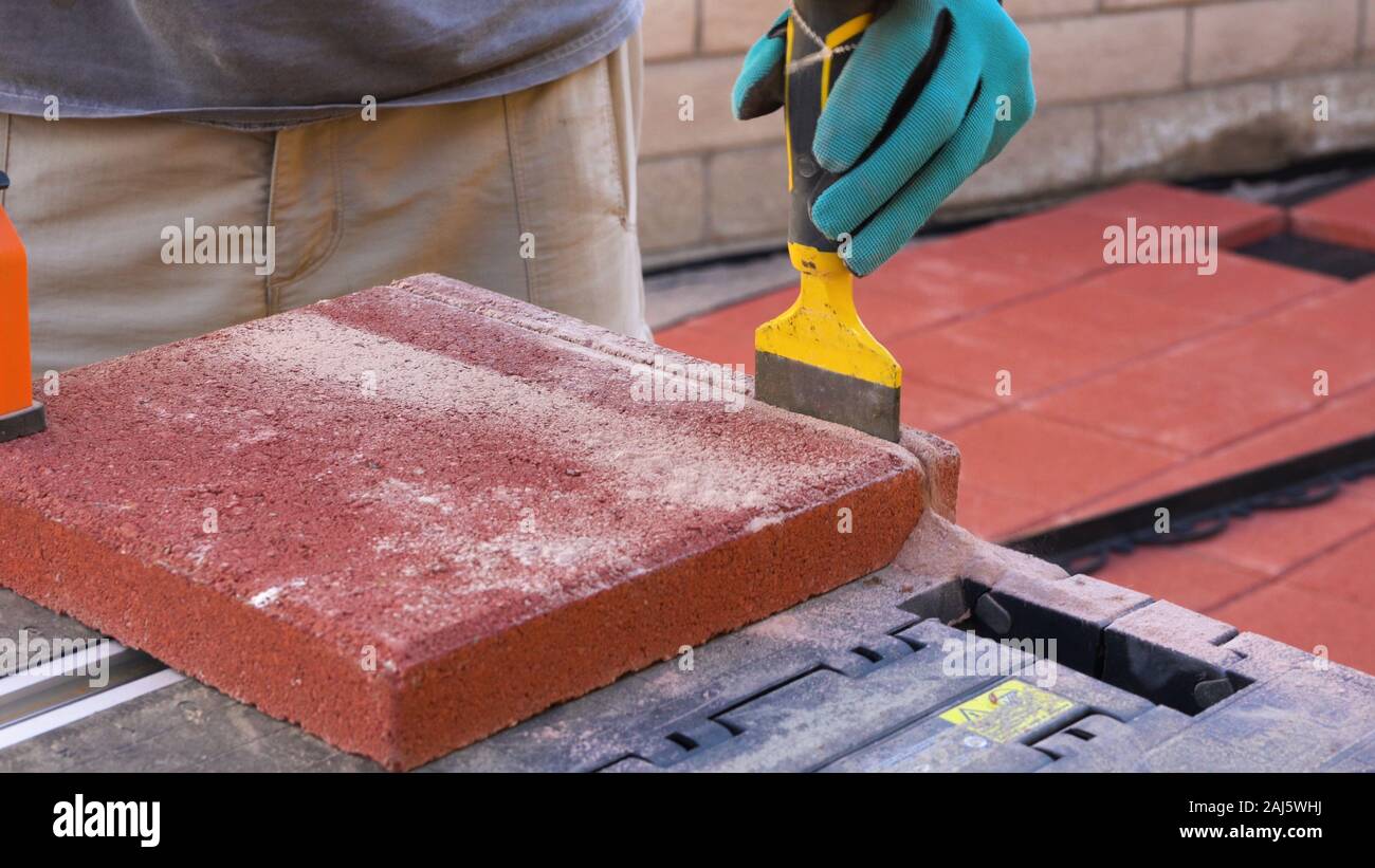 Tile cutter industry equipment. Worker cutting paving tiles for laying ...