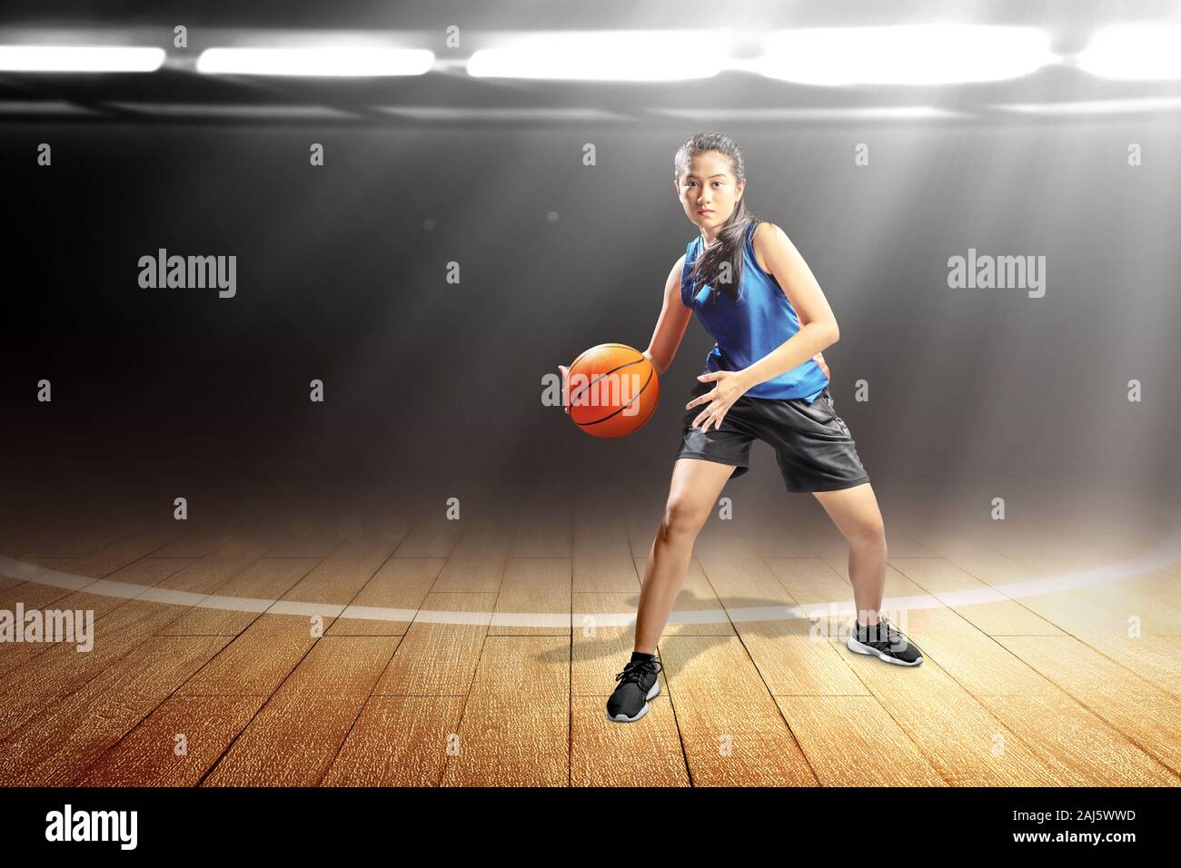 Asian woman basketball player in action with the ball on the indoor ...