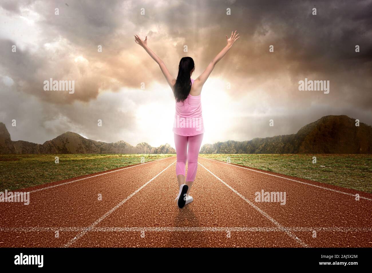 Rear view of Asian runner woman with excited expression after a run on ...