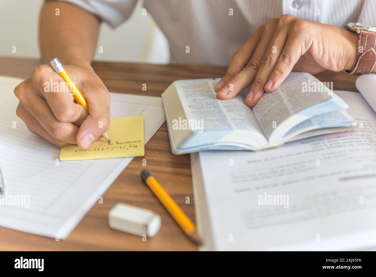 Human hands holding pencil writing into sticky notes Stock Photo - Alamy