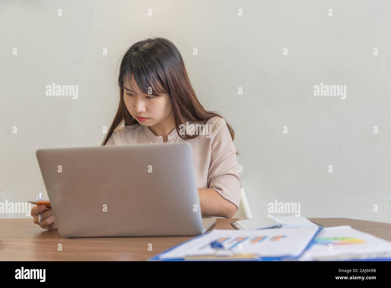 Asian employee reading sales report Stock Photo - Alamy