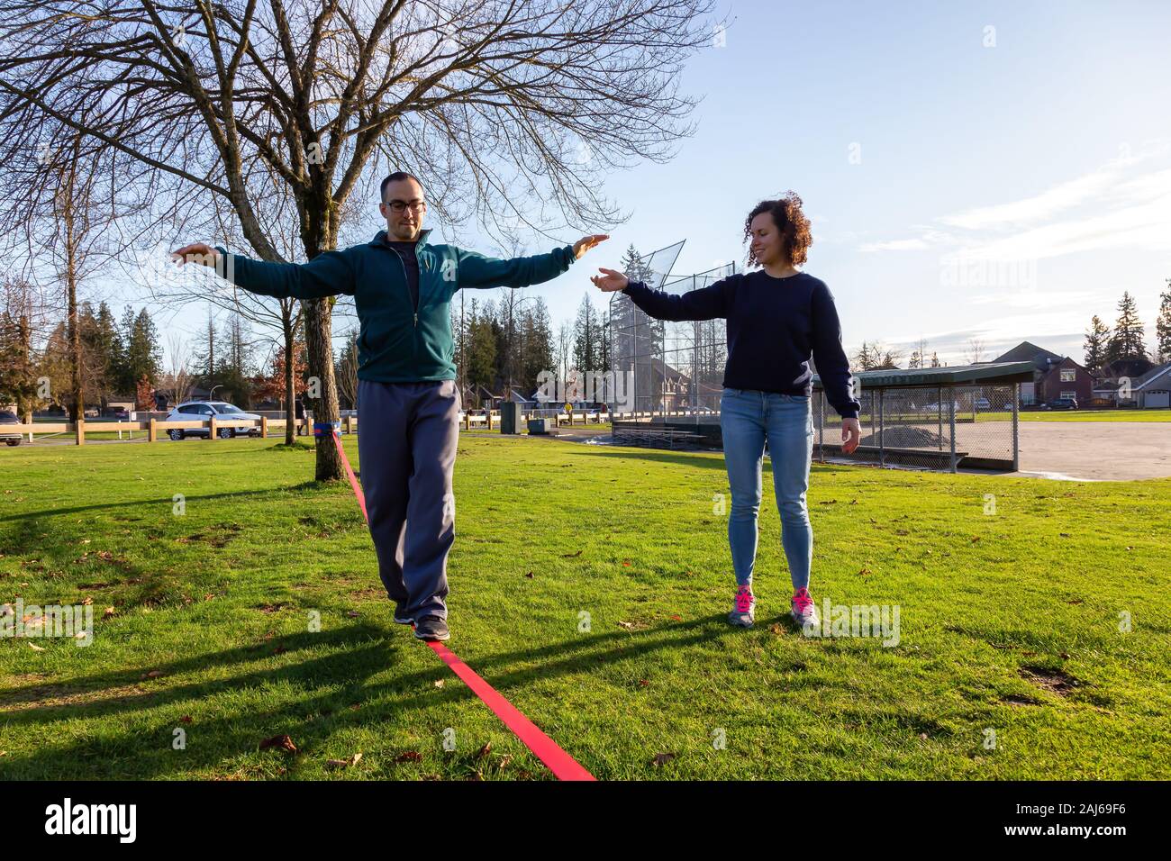 Couple walking on a Slackline in the Park Stock Photo - Alamy