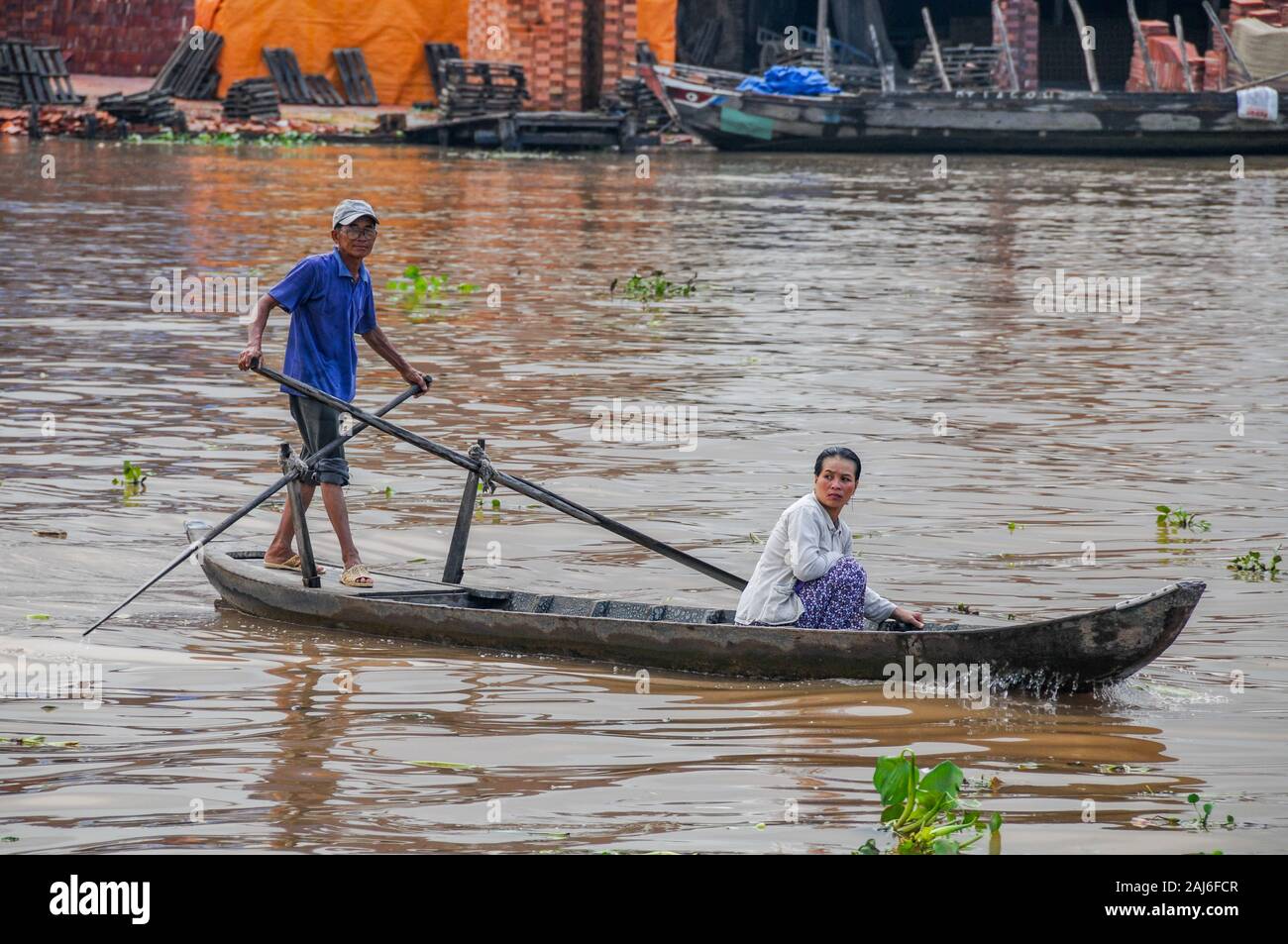 Mekong Delta, Vietnam; November 25 2008. Man rowing boat in a standing ...