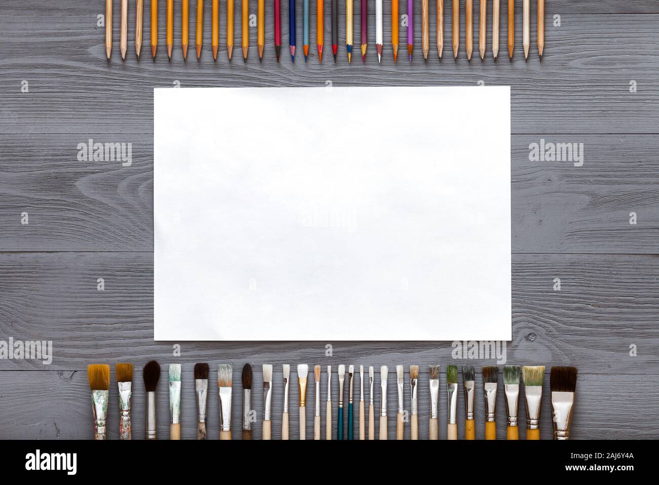 Creative table background with paintbrushes pencils and paper for ...