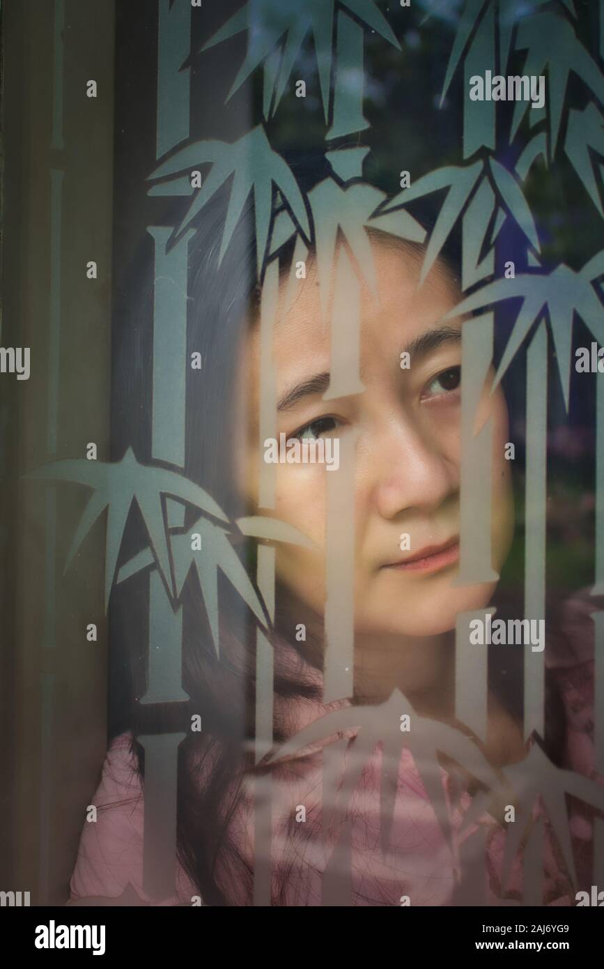 beautiful girl behind the window, glass reflection and selective focus ...