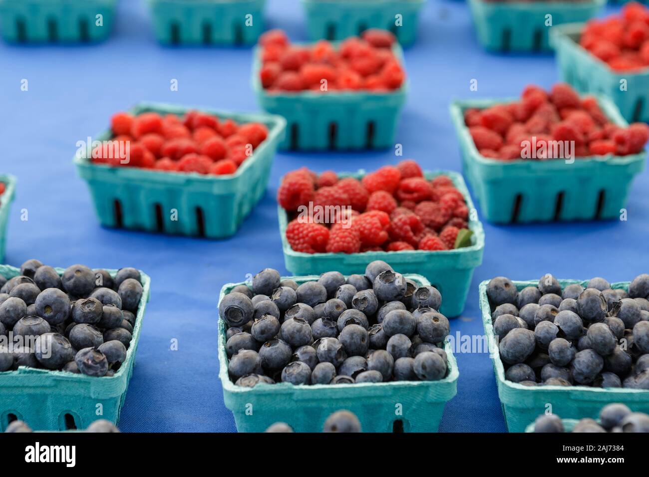 Blueberries, bilberries and raspberries in paper box containers on food ...