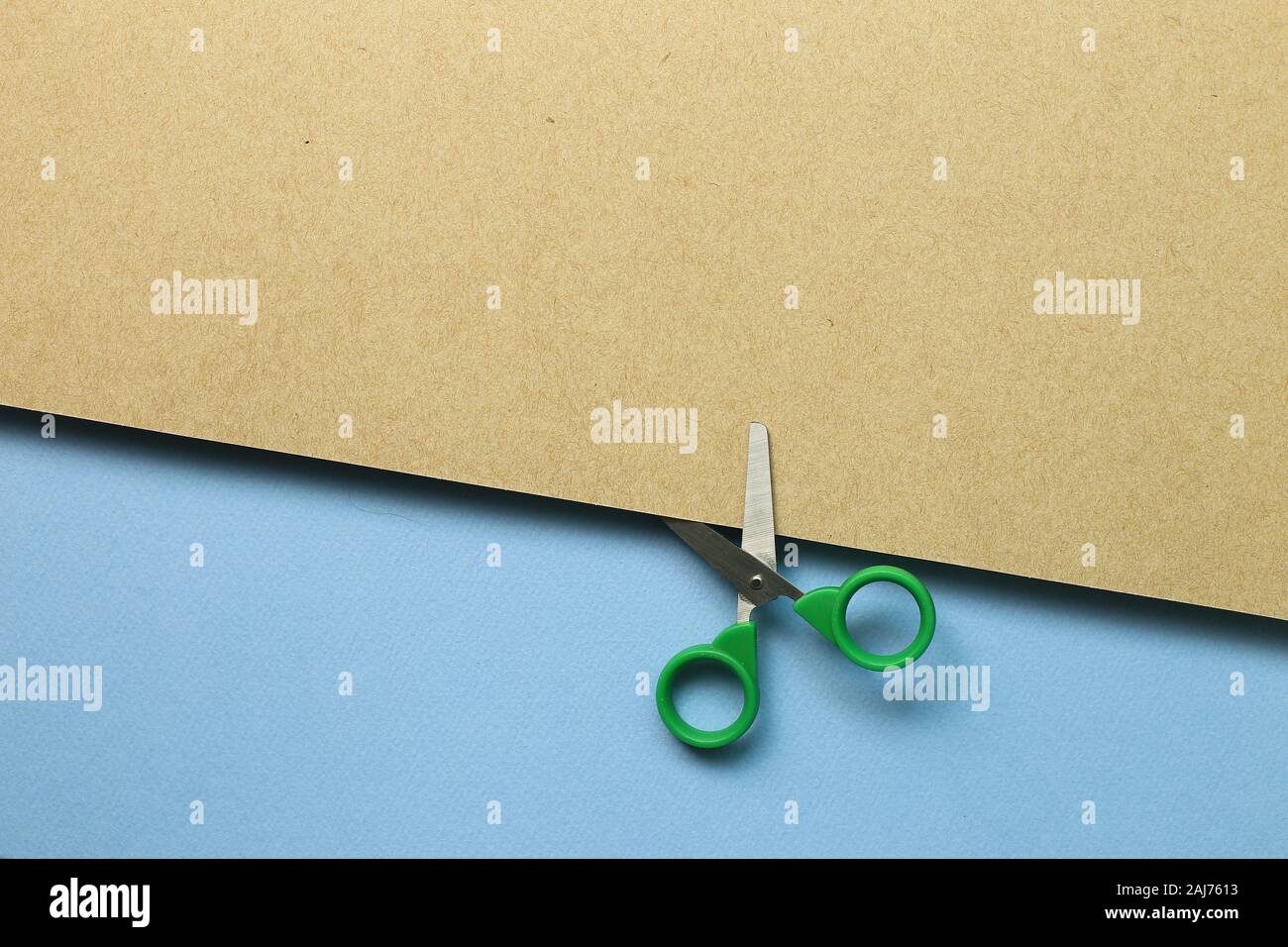 Scissors cutting brown kraft paper Stock Photo - Alamy