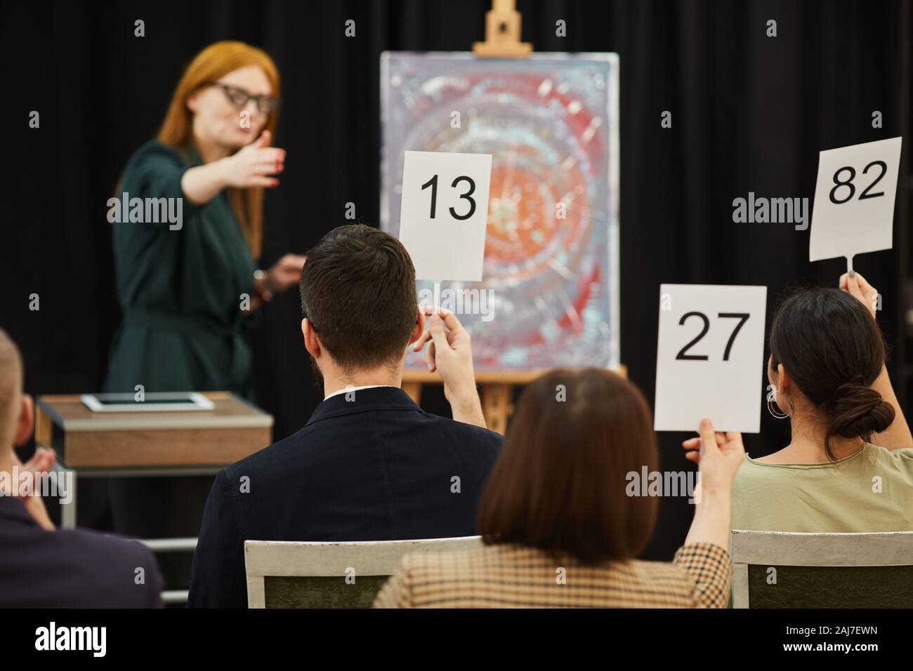 Rear view of group of people raising signs and suggesting their sum for ...