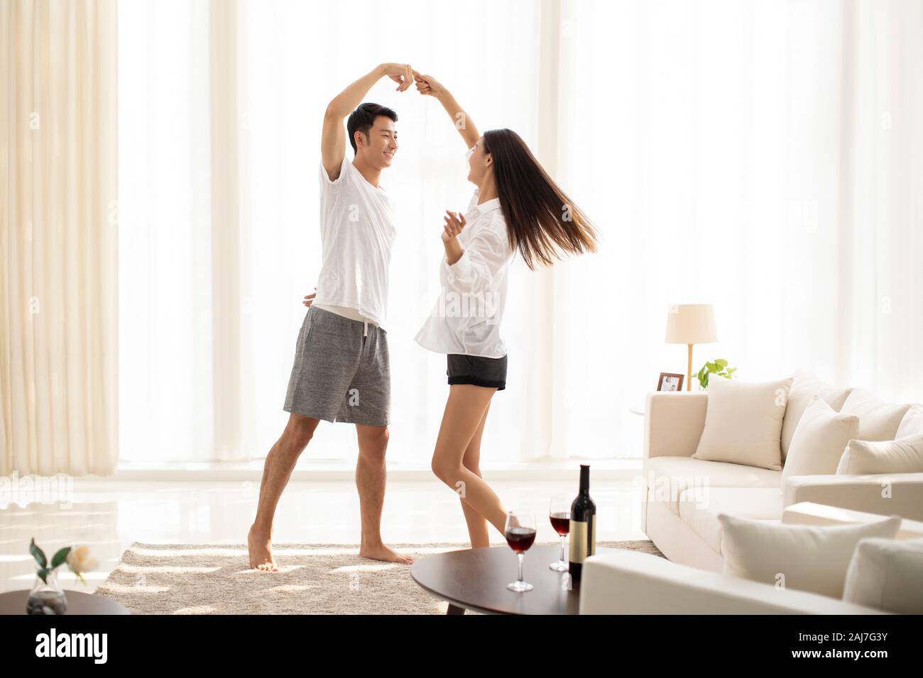Young Chinese couple dancing in living room Stock Photo - Alamy