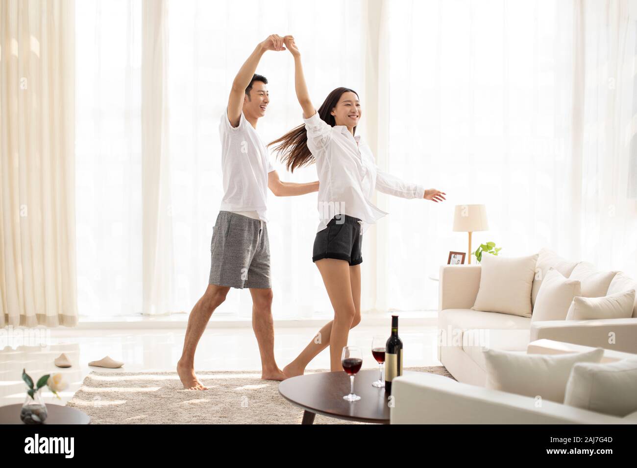 Young Chinese couple dancing in living room Stock Photo - Alamy
