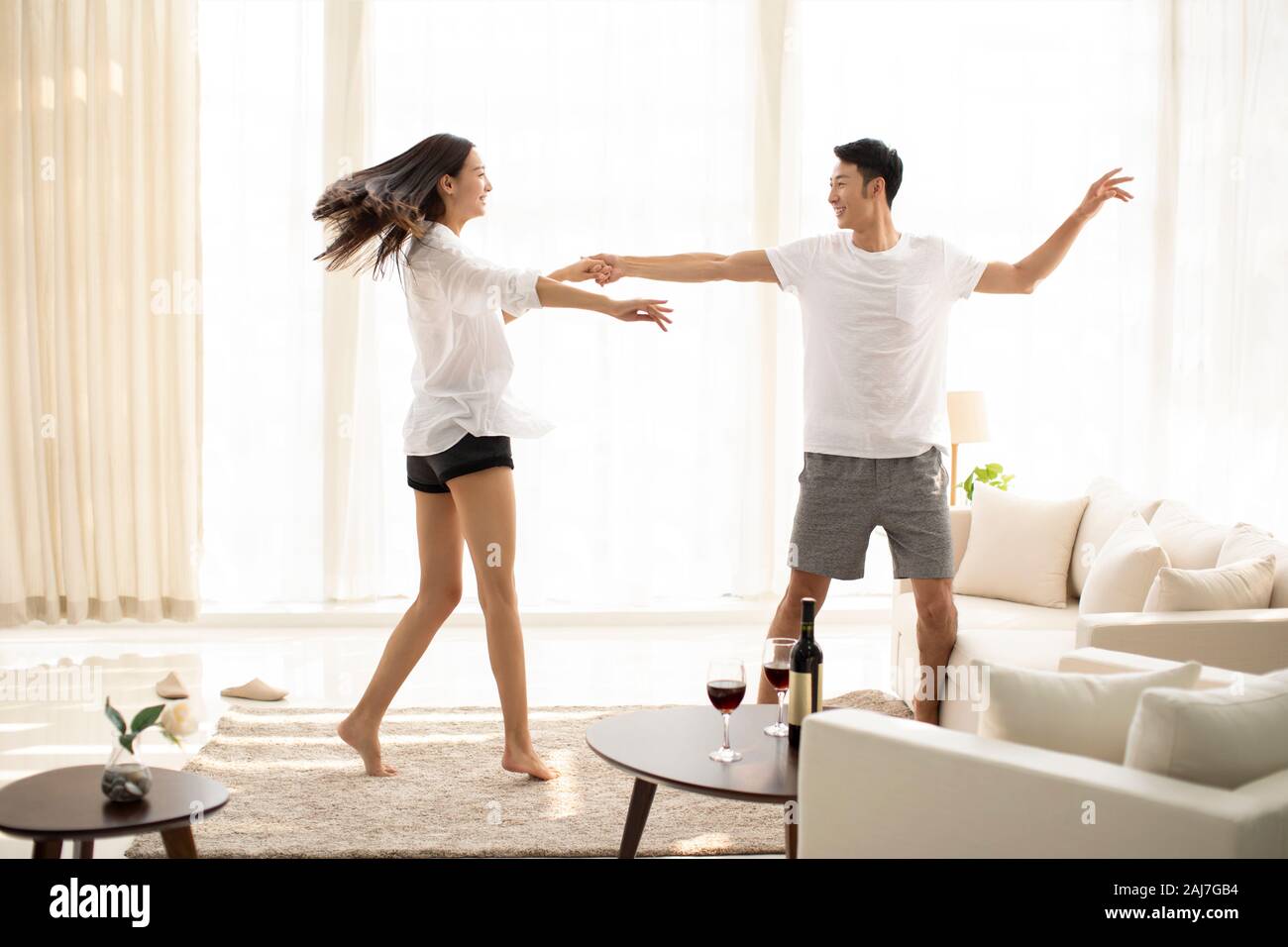 Young Chinese couple dancing in living room Stock Photo - Alamy