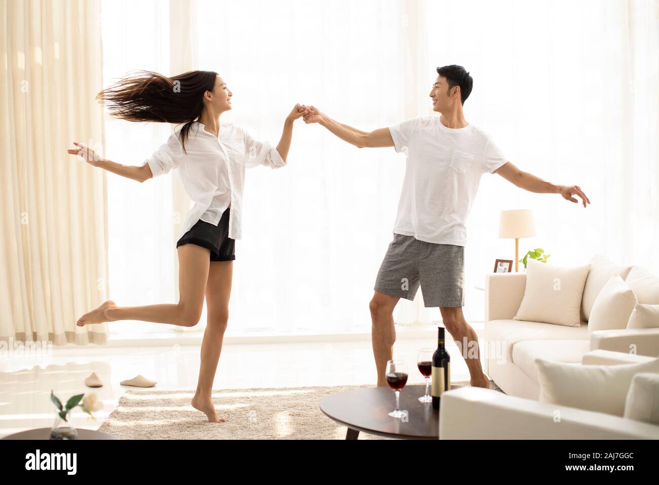 Young Chinese couple dancing in living room Stock Photo - Alamy