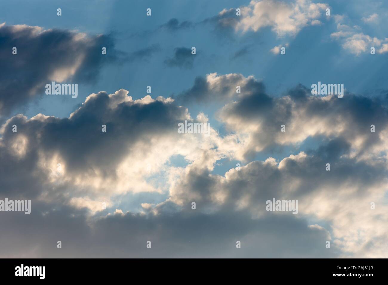 texture bright contrast sky with clouds and sun rays Stock Photo - Alamy