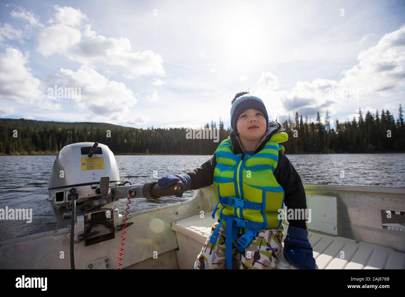 toddler boy driving motorboat on lake Stock Photo - Alamy