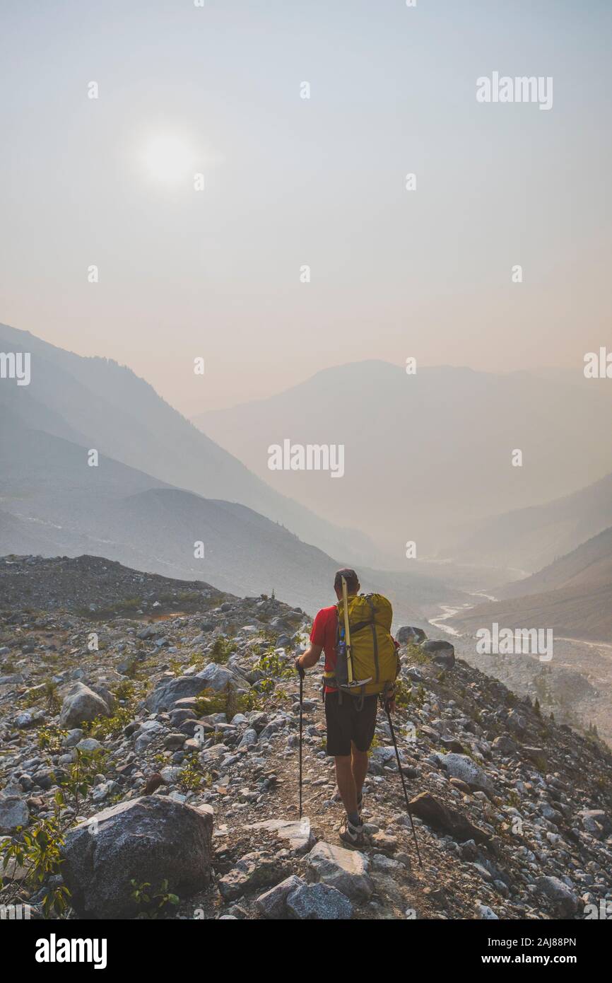 Backpacking through smoke filled apocalyptic valley Stock Photo - Alamy