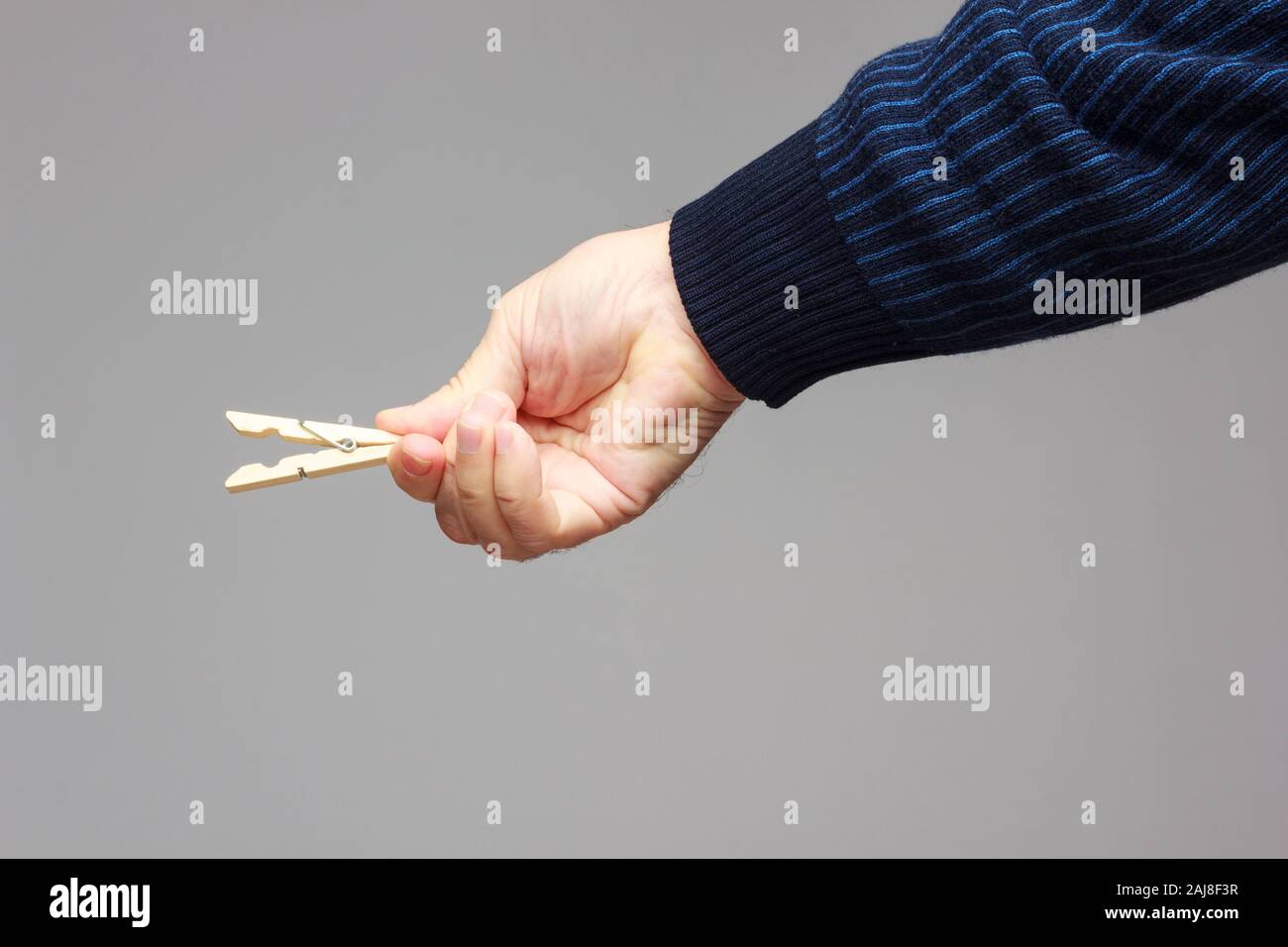 Wooden clamp, classic, to hang clothes in the hand caught by the ...