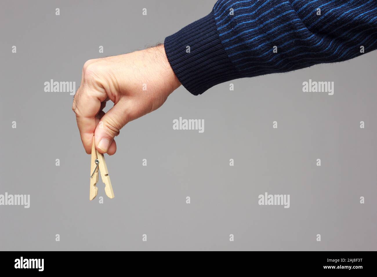 Wooden clamp, classic, to hang clothes in the hand caught by the ...