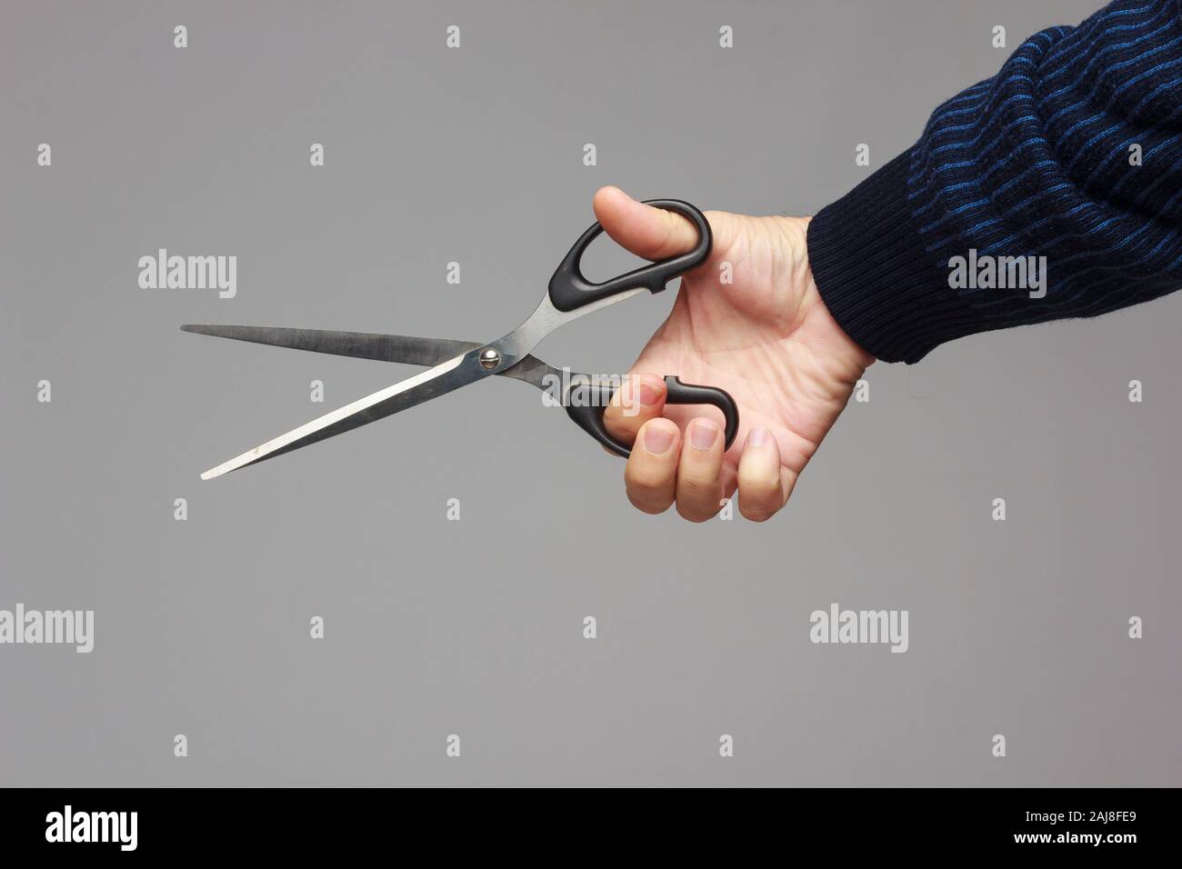 Large professional scissors in a person's hand, prepared to cut or trim ...