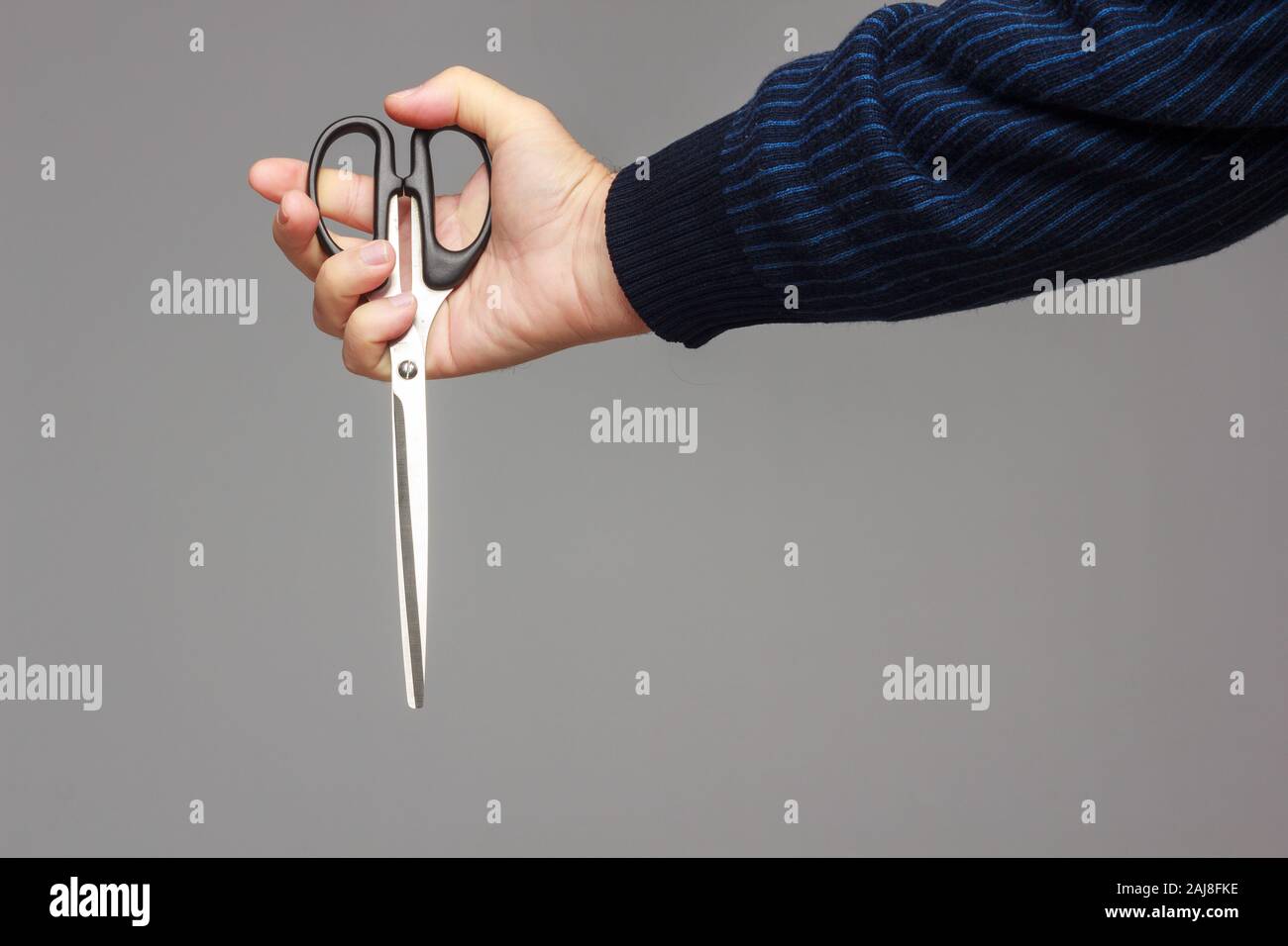 Large professional scissors in a person's hand, prepared to cut or trim ...