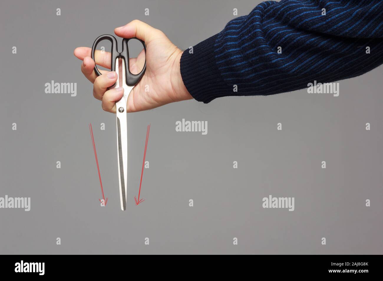 Large professional scissors in a person's hand, prepared to cut or trim ...