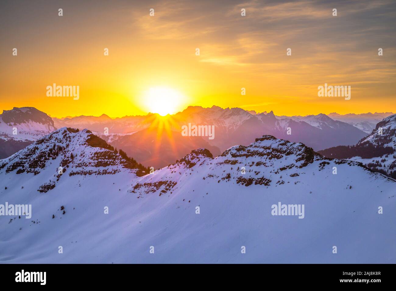 Sunrise in snowy mountains with fog and light beams Stock Photo - Alamy