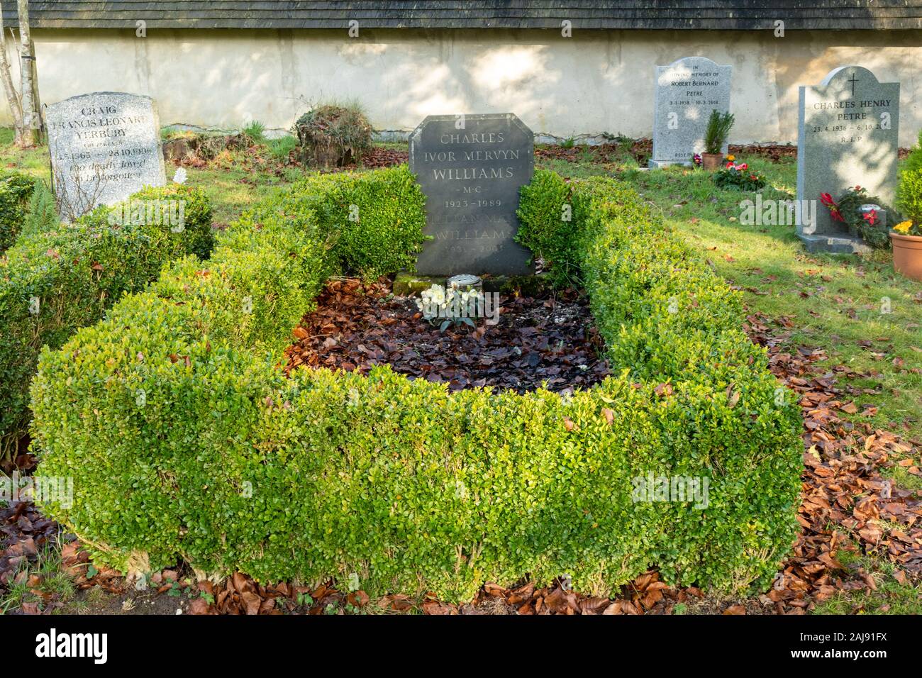 Graves surrounded by low hedges in All Saints churchyard at Tunworth ...