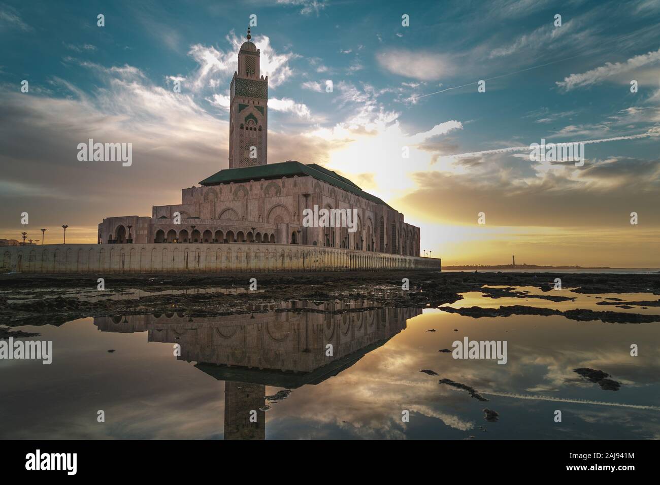 view of Hassan II mosque against sky with reflection on water ...