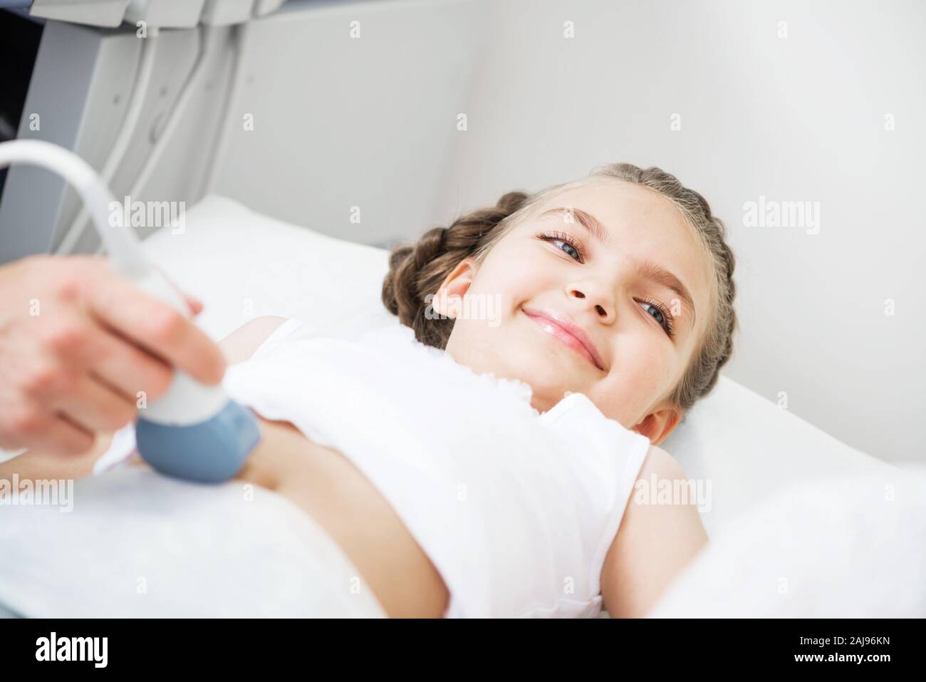 Medical exam of little girl by ultrasound equipment. Sonographer moving ...