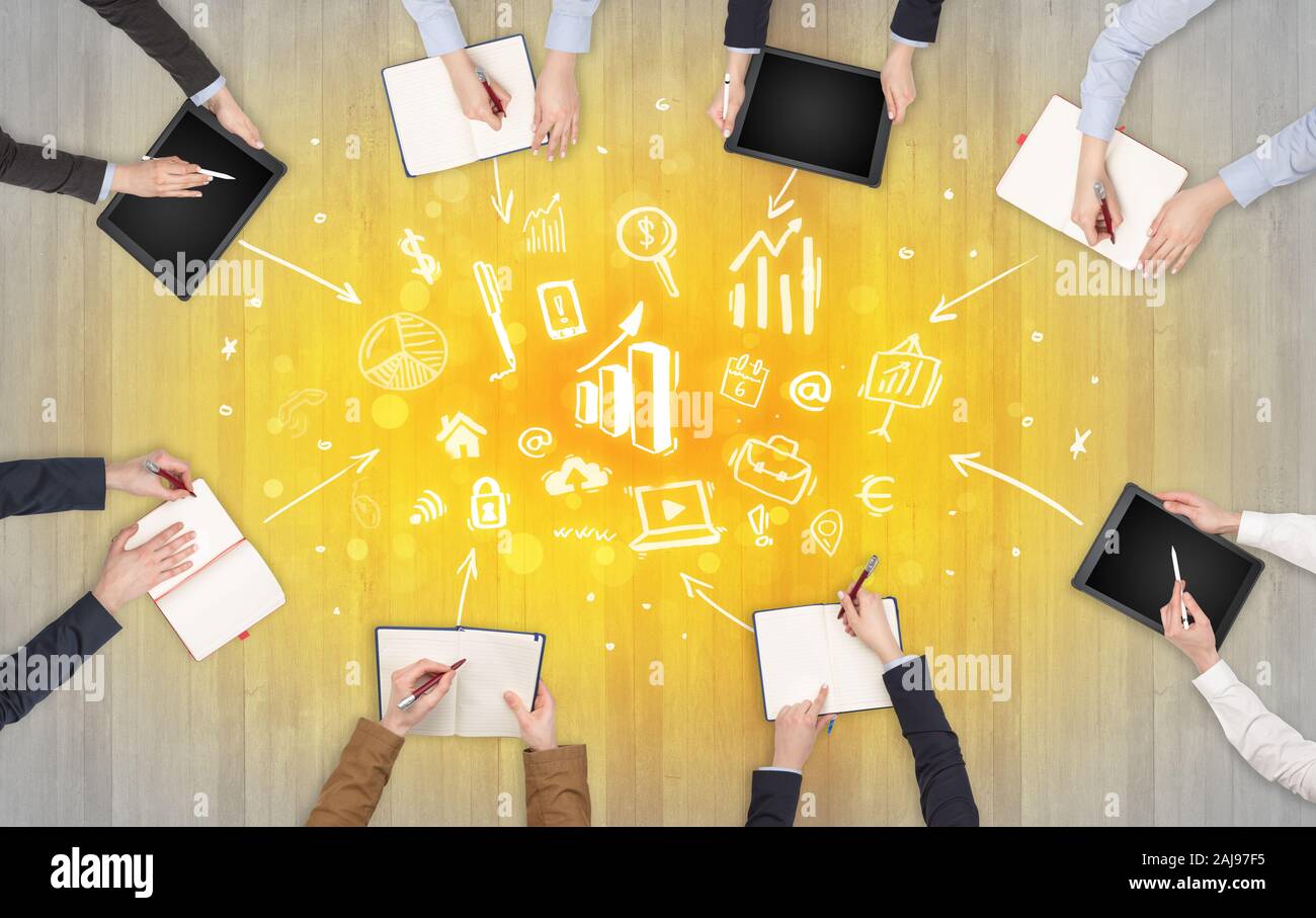 Group of people with devices in hands making reports together on laptop ...