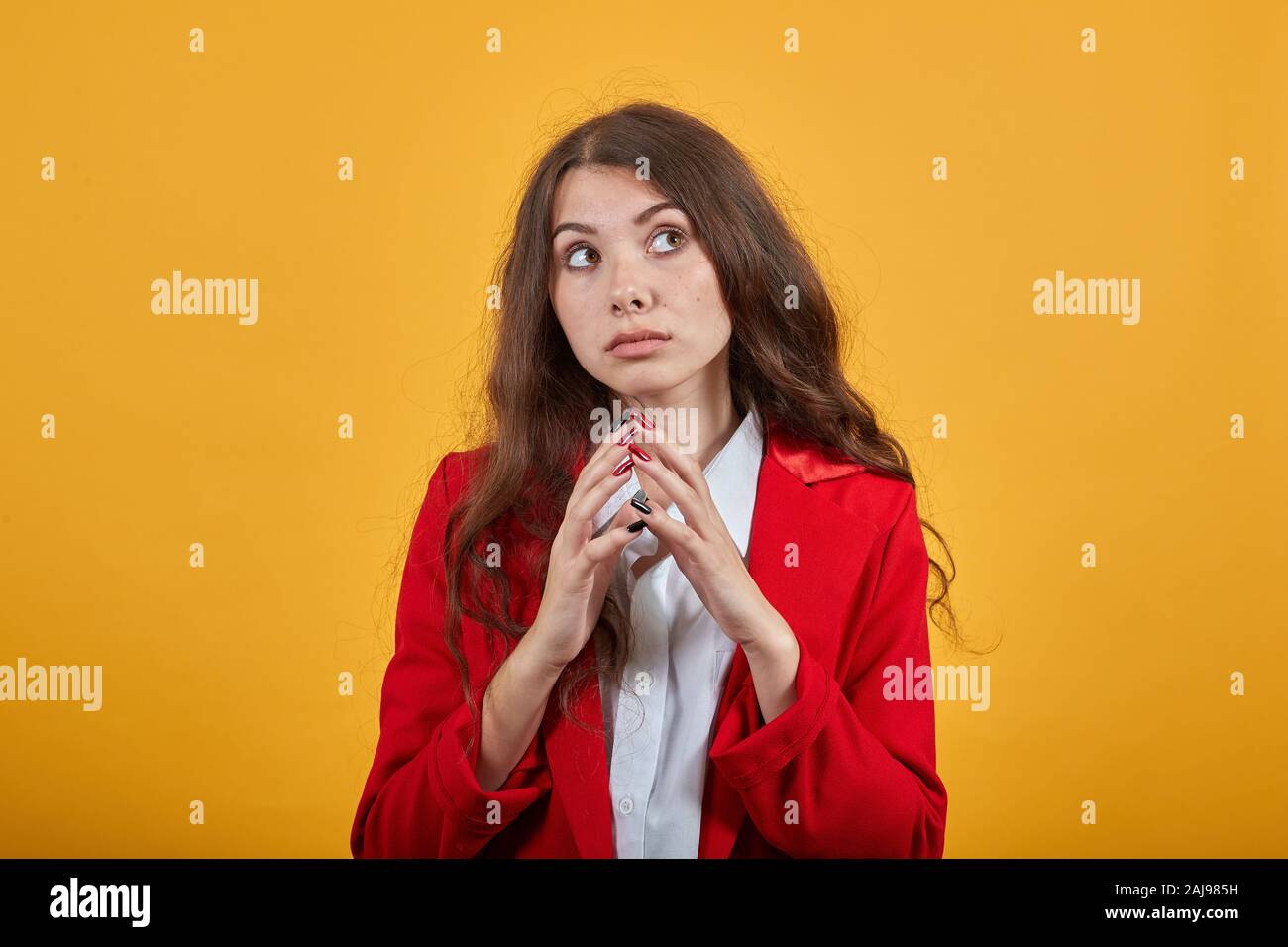 Serious woman keeping fingers together, having plan Stock Photo - Alamy