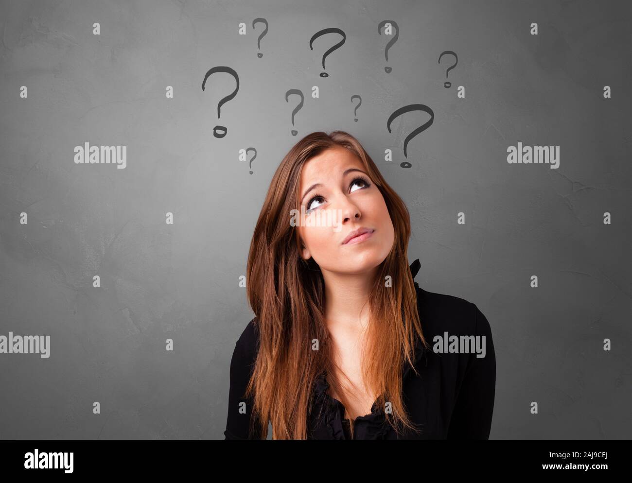 Person with question marks around face Stock Photo - Alamy