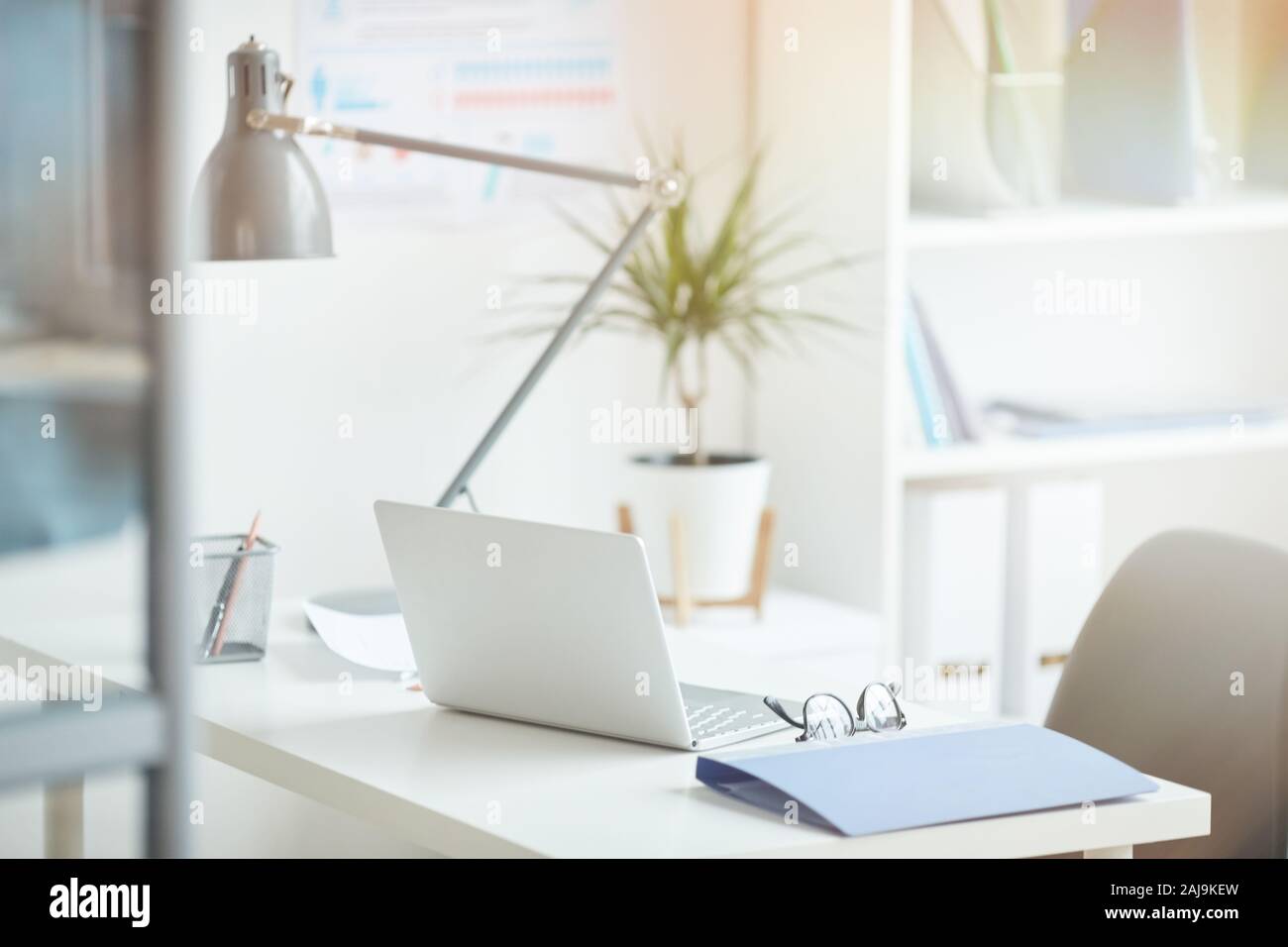Close-up of workplace with laptop and folder on it at light modern ...