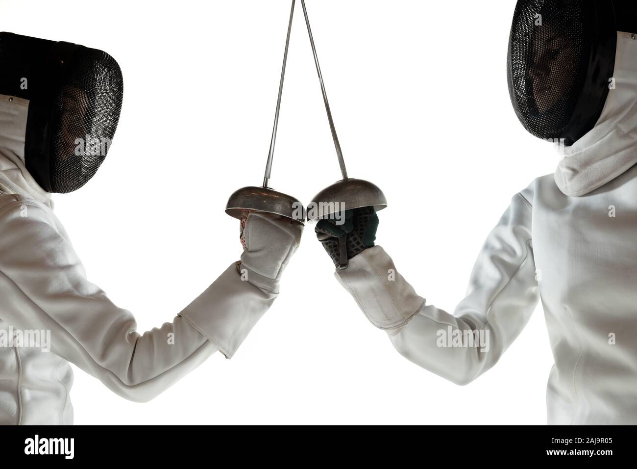 Teen girls in fencing costumes with swords in hands isolated on white ...