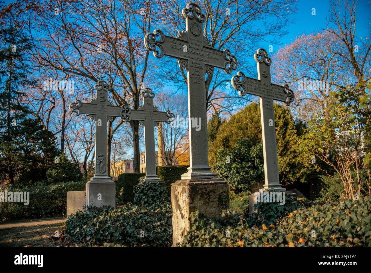 Old weathered crosses on a german graveyard in Berlin on a bright ...